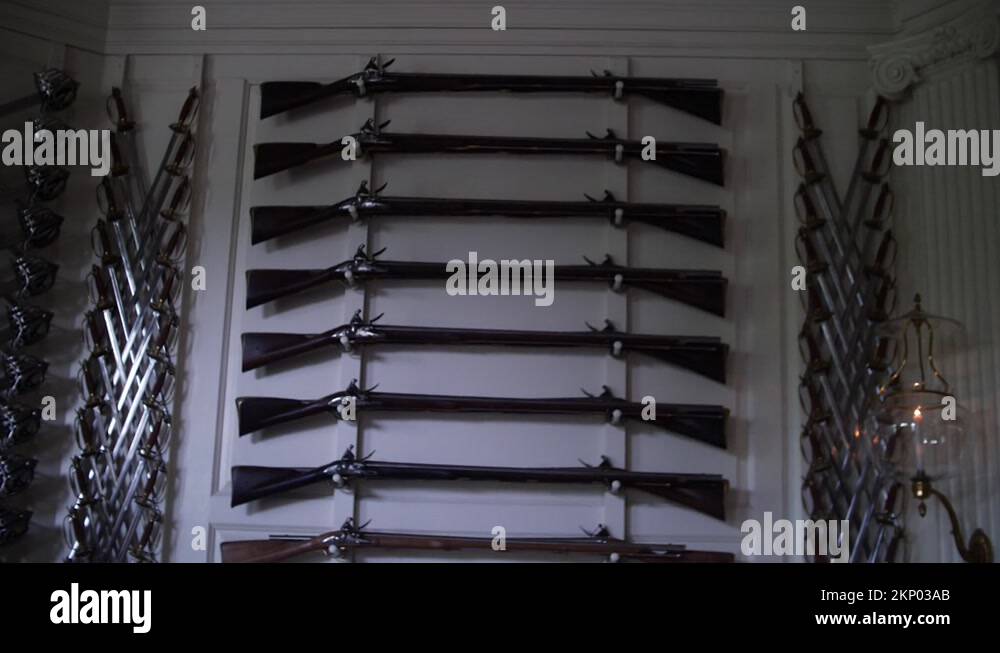 Colonial rifle guns in a row on a wall being shown collection Stock ...