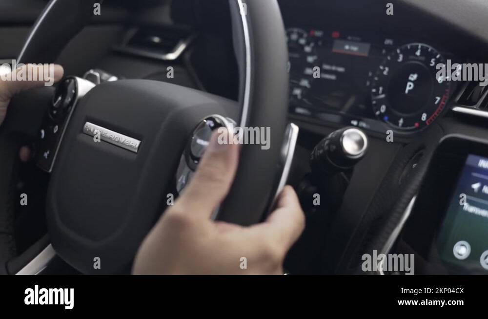 man using steering wheel of new range rover velar , modern automobile ...