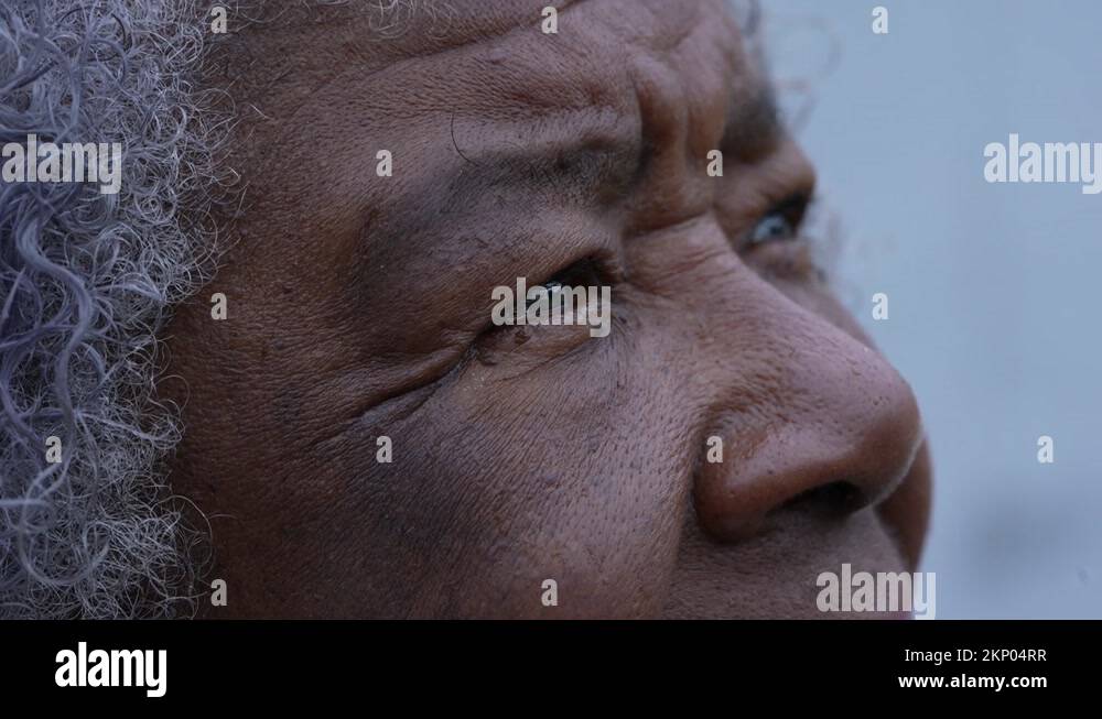 An African older woman looking up at sky with HOPE and FAITH macro eyes ...