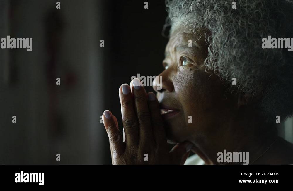 An older African woman praying to God closing eyes with HOPE and FAITH ...