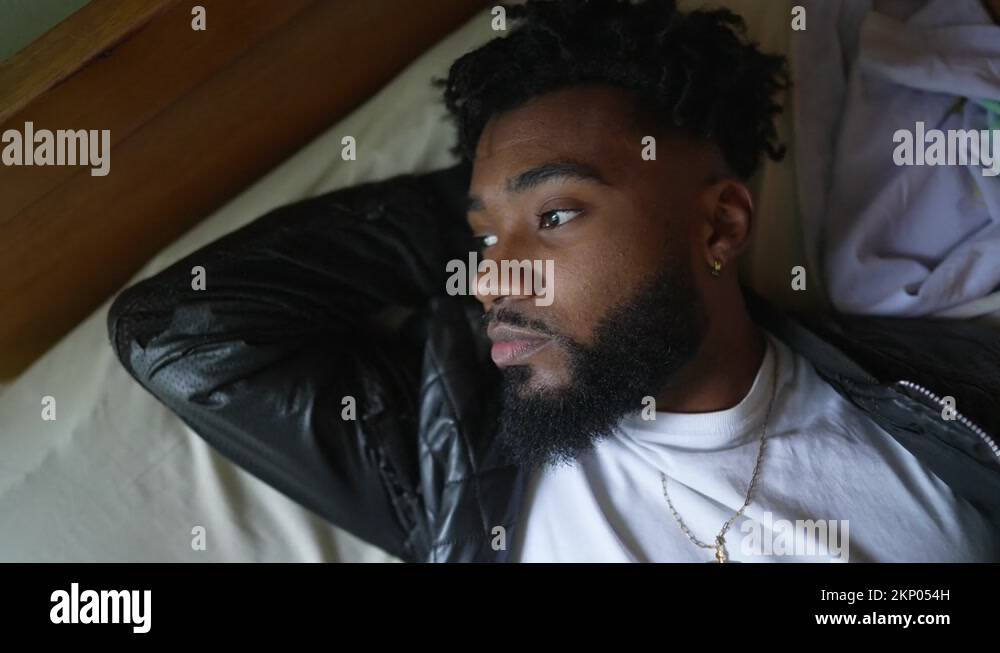 Pensive person lying in bed thinking an african man thinking Stock ...