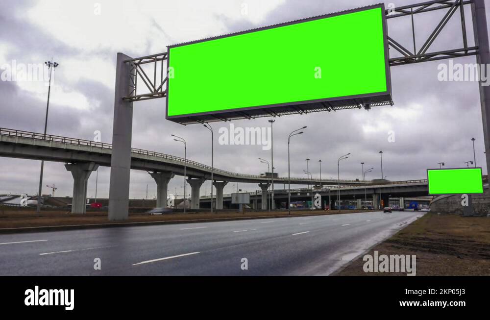 Large billboards green screen near the expressway. Cars, clouds ...