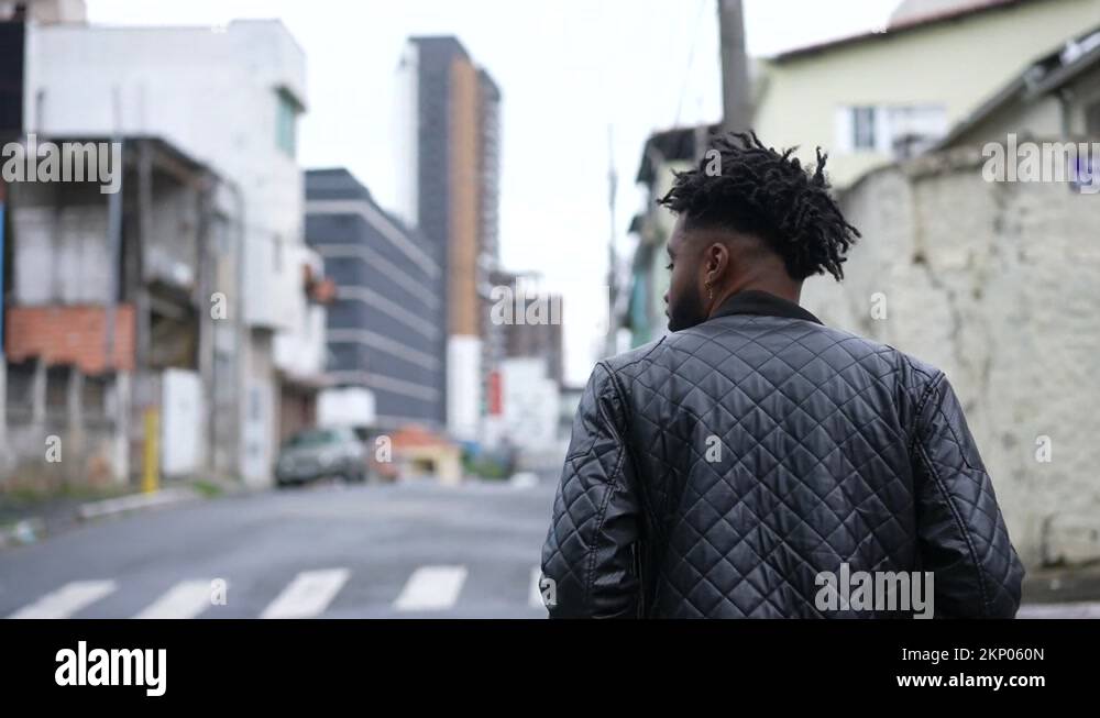 Back of young black man crossing street in urban city Stock Video ...
