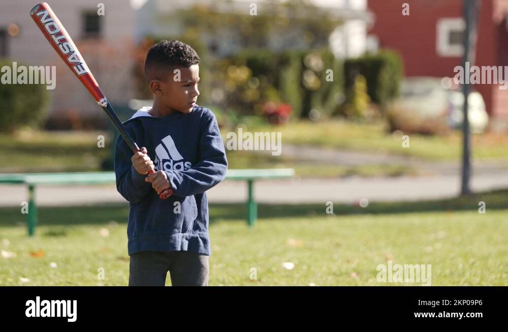 Young boy swings a bat missing a baseball in a sunny park Stock Video ...