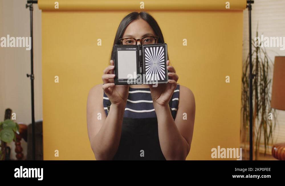 Young Asian woman in a studio holds up a lens focus chart Stock Video ...