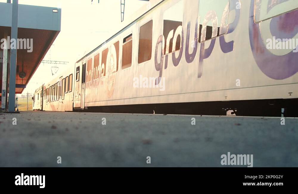 Static, low to ground. Public outdoor trains arrive and leave station ...