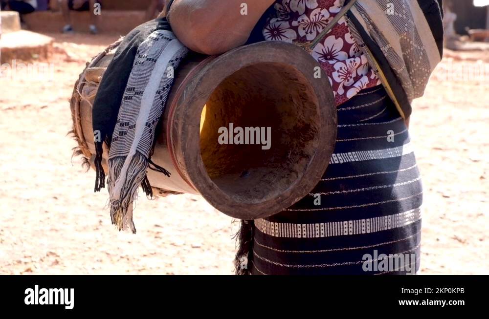 Women wearing traditional Timorese tais clothing with a homemade drum ...