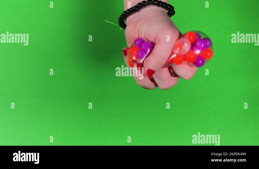 4k top view young woman's hand squeezing stress ball over green screen ...