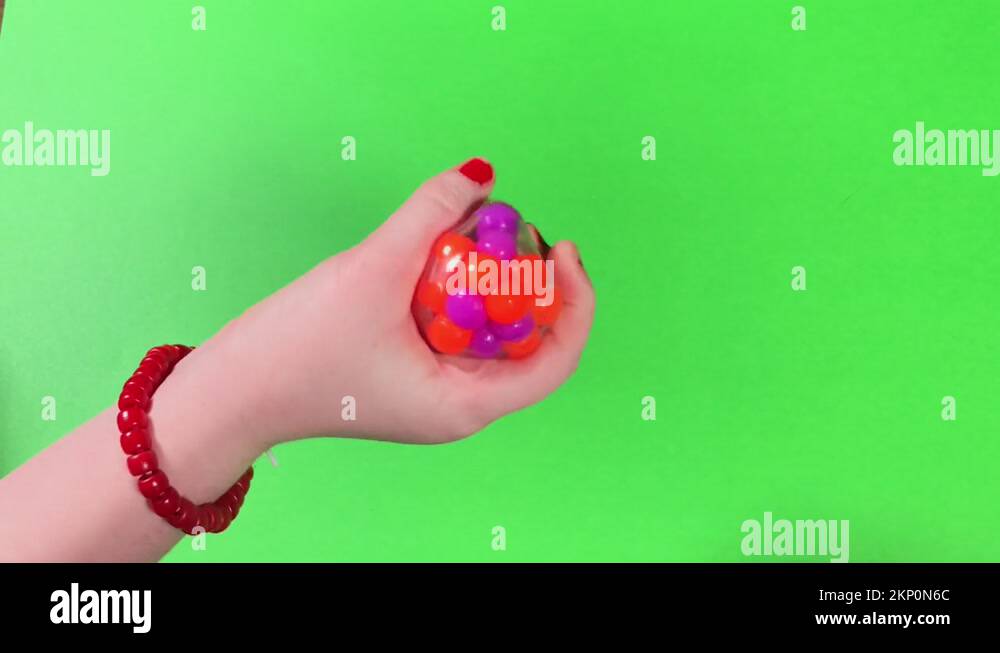4k side view young woman's hand squeezing stress ball over green screen ...