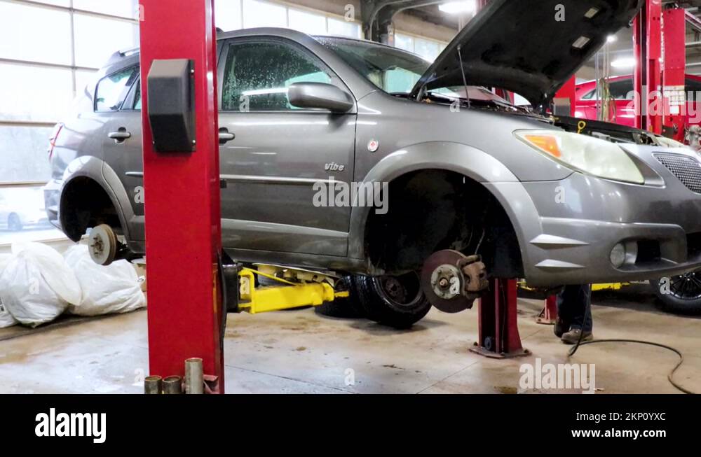 Car being lowered on a hoist, with wheels removed Stock Video Footage ...
