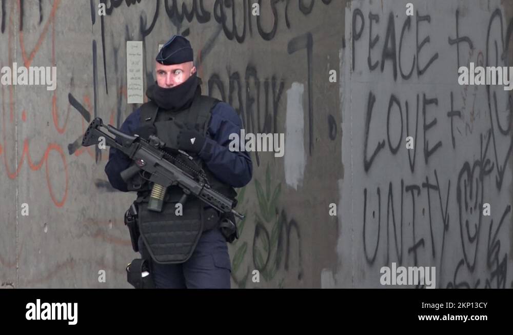 A CRS police officer armed with an assault rifle stands guard in front ...