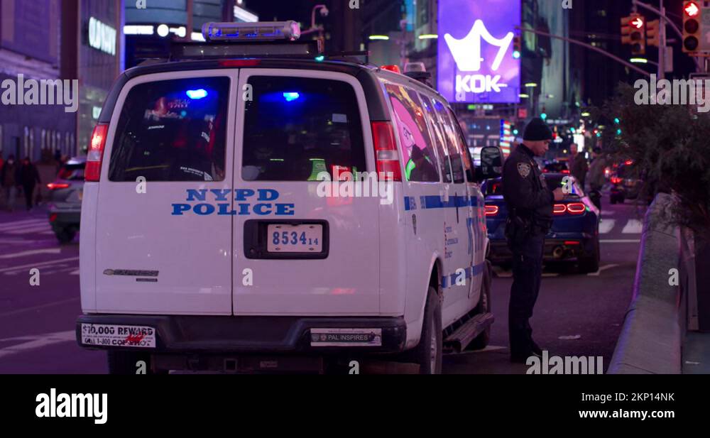 Times Square walking people drive police cars lit billboards, a lot of ...