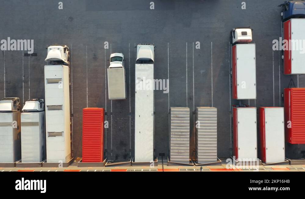 Semi-trailers trucks drive in and out of warehouse ramps for load and ...