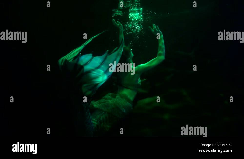 underwater mystery of ocean, enigmatic water-nymph is floating in dark ...