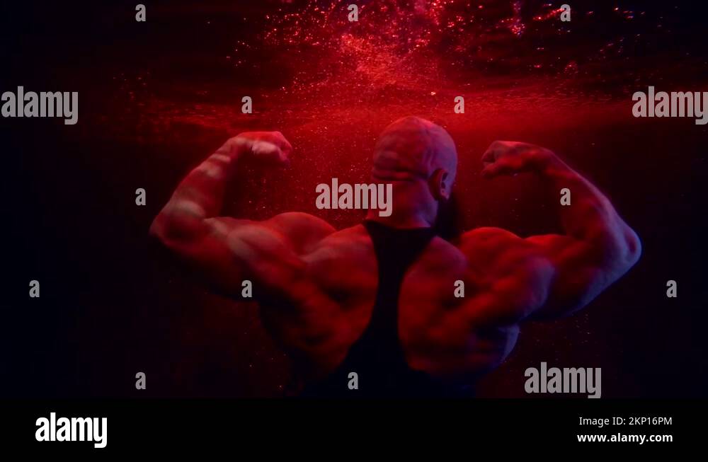 brawny bodybuilder is showing his muscular back and arms, floating ...