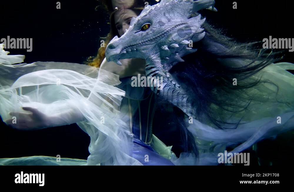 A fantastic dragon under water and his companion a woman in a long ...