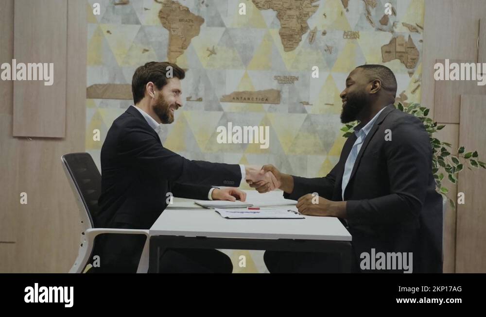Positive closure of the business meeting. Interracial handshake and ...