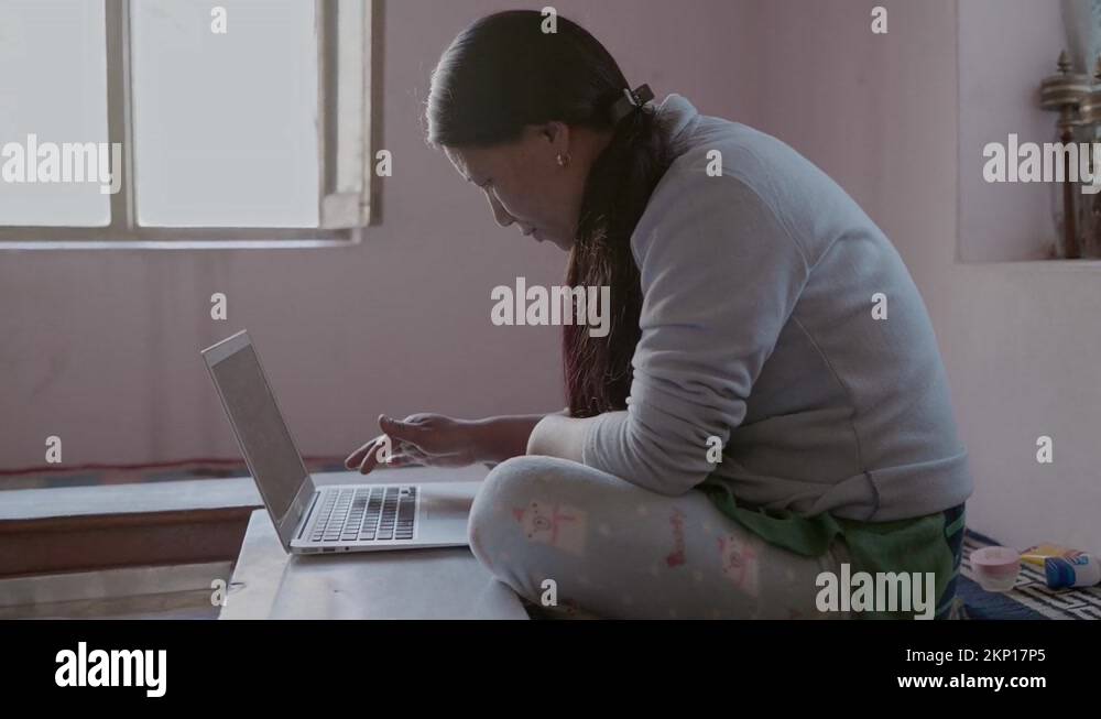 Rural Asian Indian middle-aged woman sitting in house and working on a ...