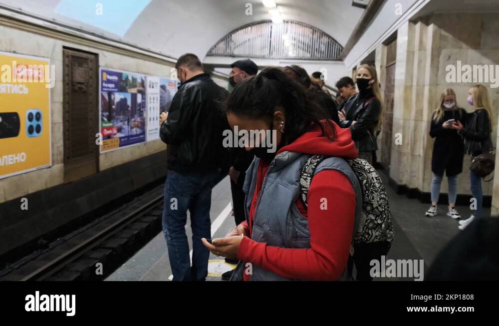 Crowd of masked people on the platform in the subway is waiting for the ...