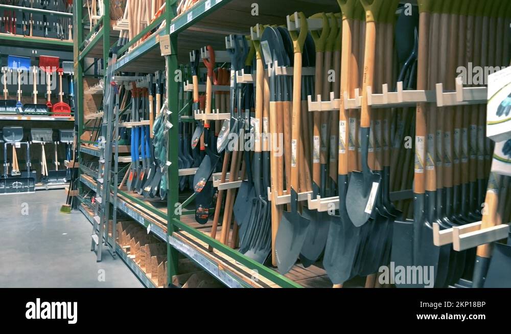 Hardware store departments and shelves with rows of shovels and hand ...