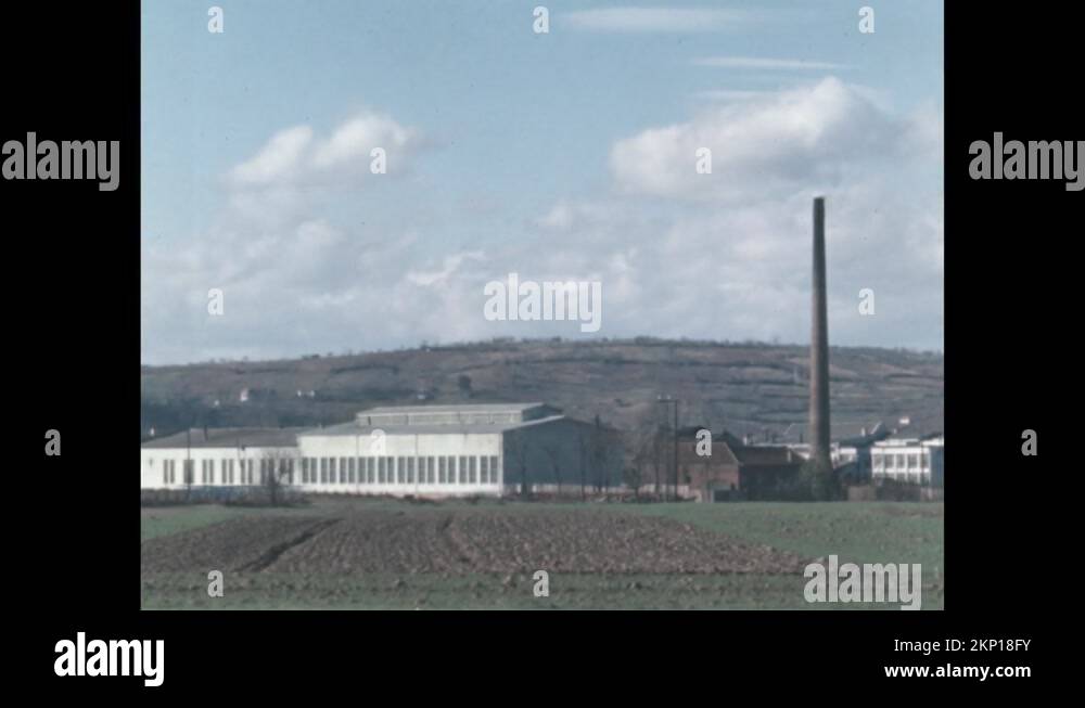 1960s: Factory building and smoke stack stand near farm field ...