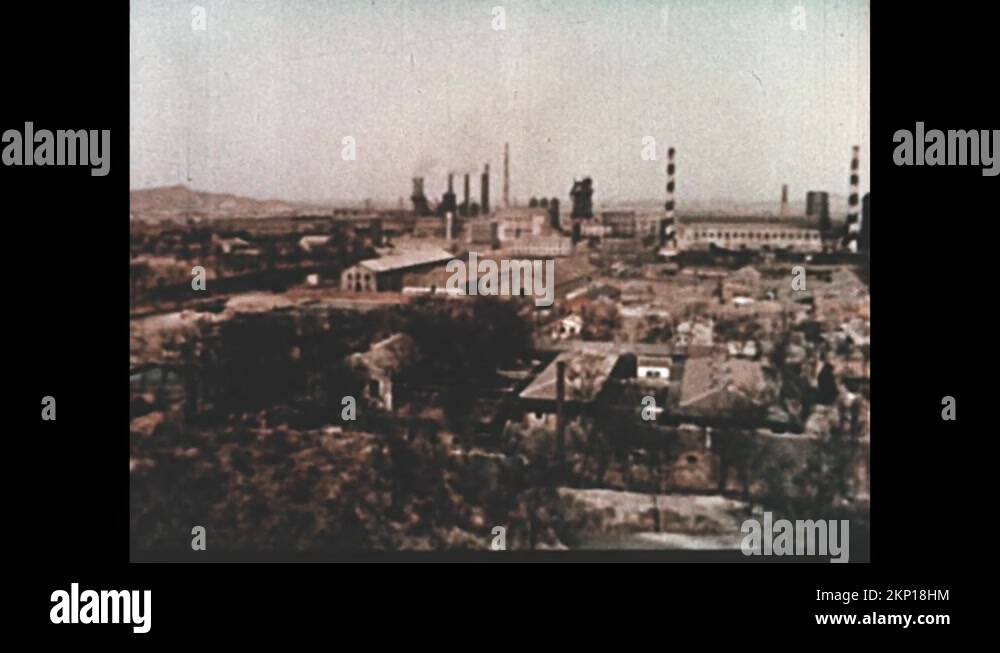 1960s: Industrial area of city. Ships and factories along the river ...