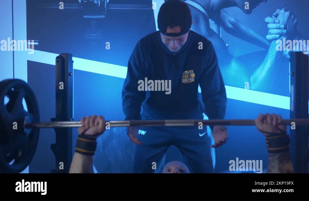 Muscular Bodybuilder Lifting A Barbell While Lying On Bench In The Gym ...
