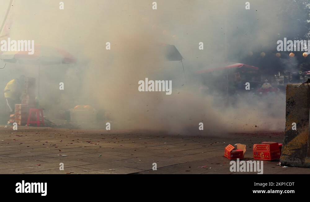 Chinese fire crackers popping explosively within thick plume of smoke ...