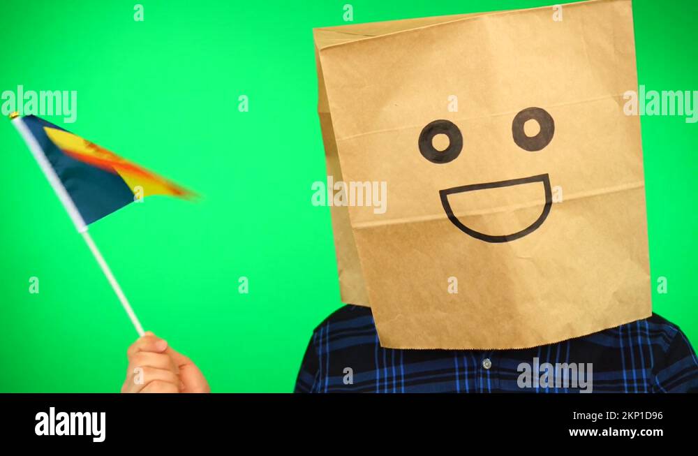 Portrait of man with paper bag on head waving Andoran flag with smiling ...