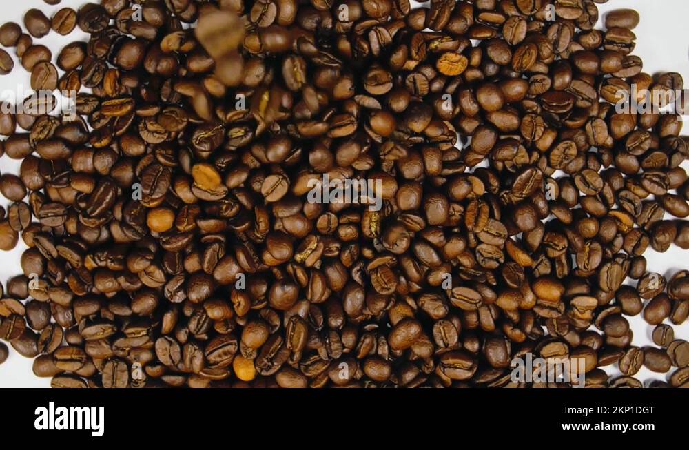 The coffee beans spin rotate quickly fast fly, dispart, splash to the ...