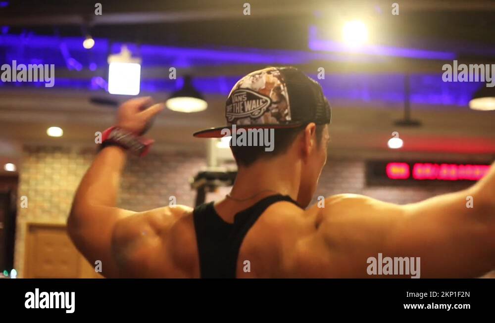 Rear angle of body builder flexing muscles in gym Stock Video Footage ...