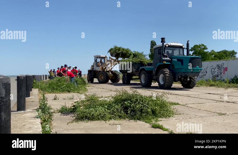 City Cleaning day. Young people and road equipment clean up garbage and ...