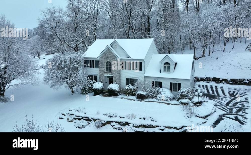 Two story home on hillside. American house covered in winter snow ...