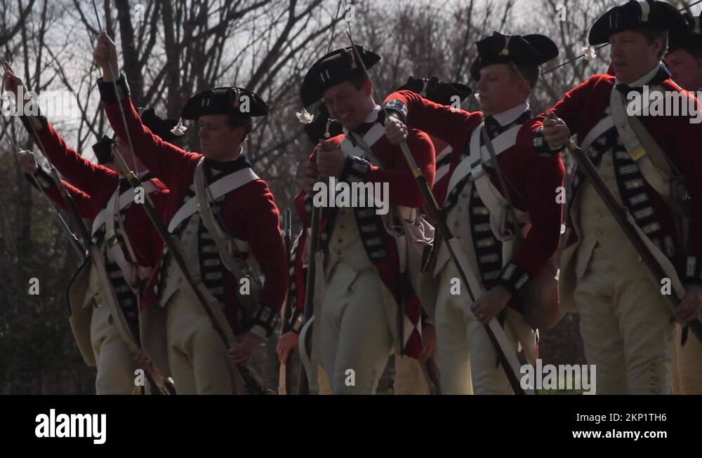 British Redcoat Re-enactors armed with flintlock muskets practice ...