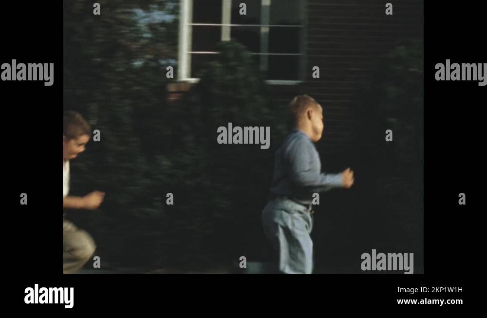 1950s: Boys run across front yards. Boy enters house while friend waits ...