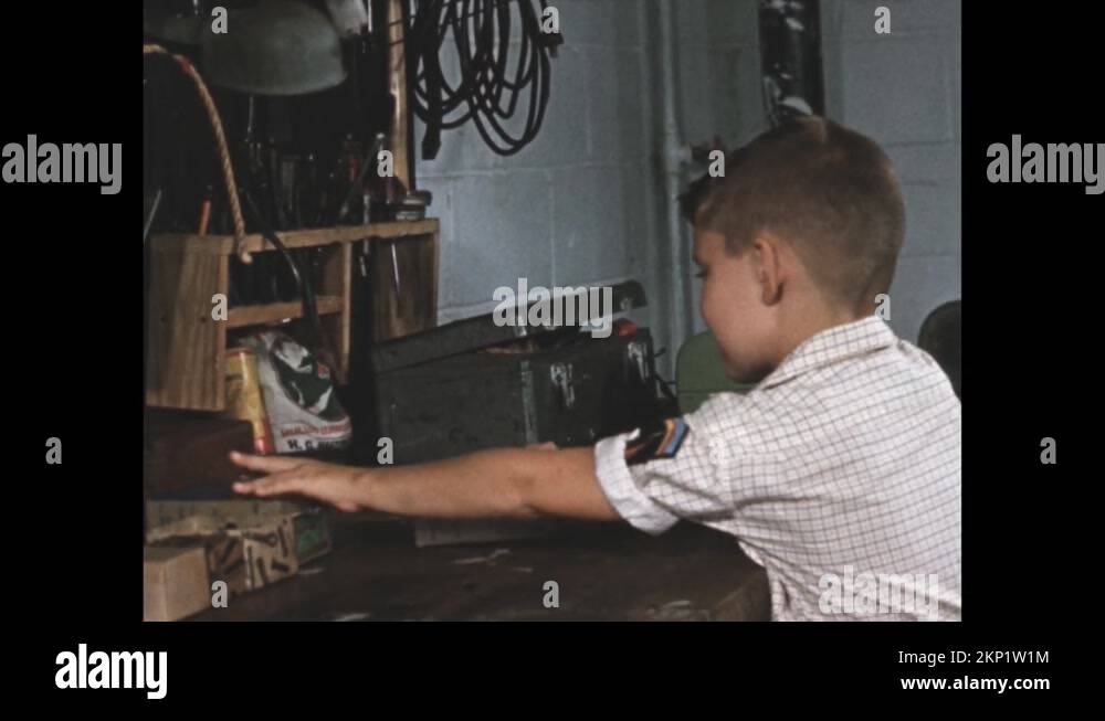 1950s: Boy removes boxes of nails from workbench. Man points to box of ...