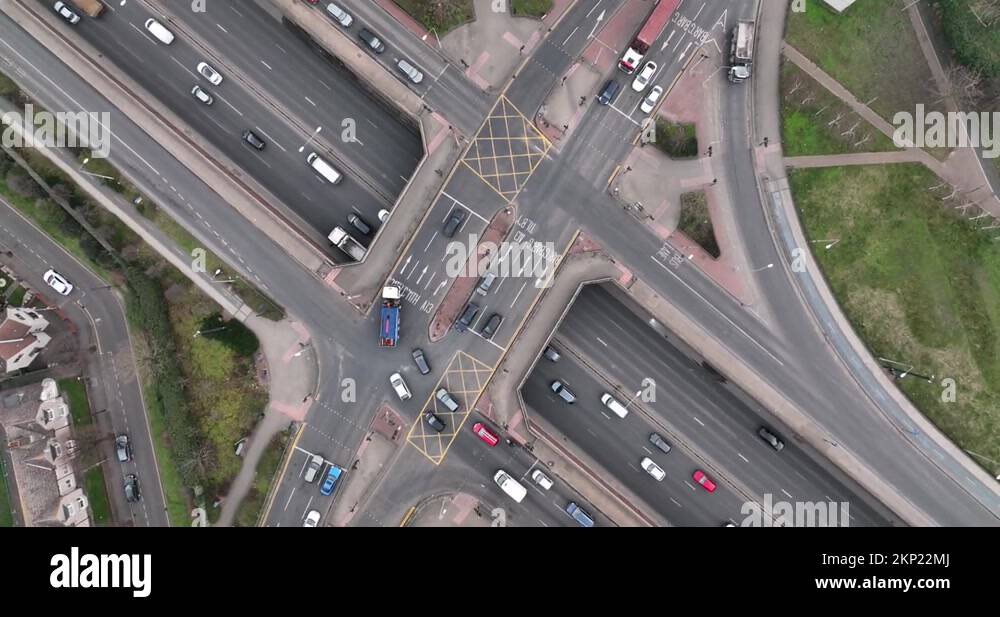 Vehicles passing road intersection and driving on bridge over highway ...