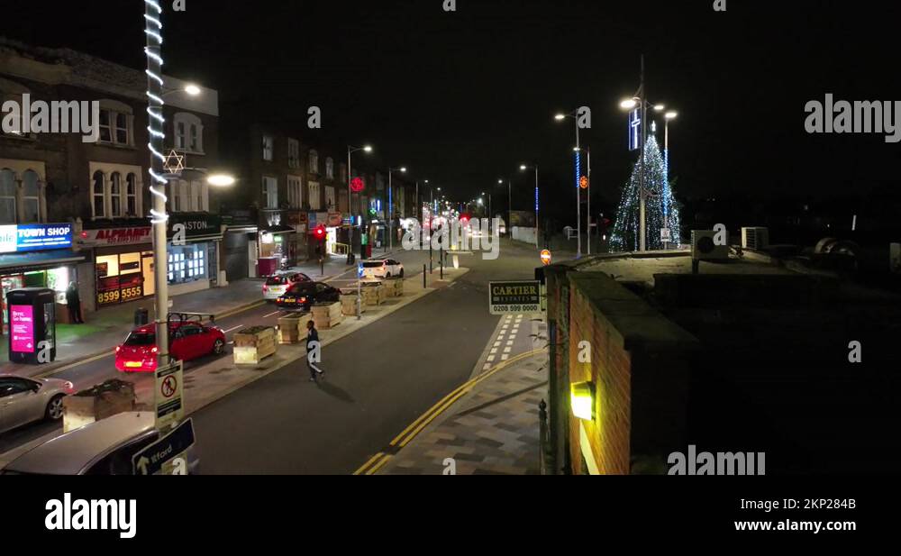 Traffic track in front of market shops and lighting tree on night time ...