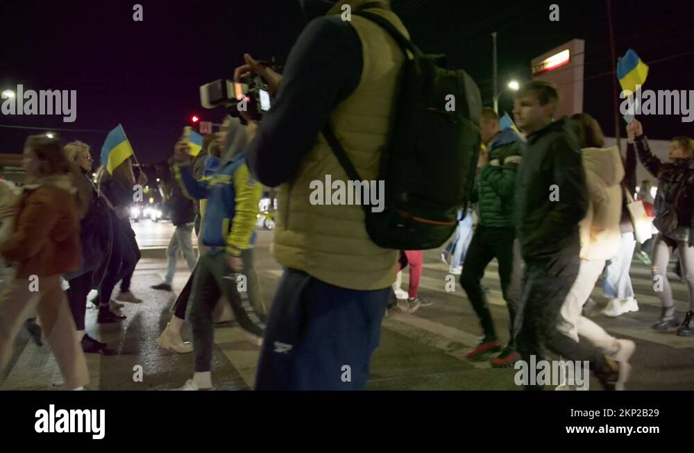 Crowd waving yellow and blue Ukrainian flags and STOP WAR, STOP PUTIN ...