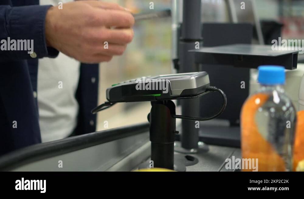 Male consumer paying for purchases with credit card and standing at ...