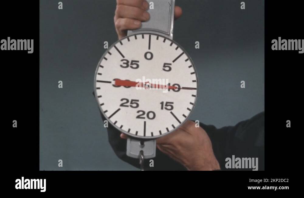 1960s: Hands hold a spring scale, showing "10". Slate. A 10 pound ...
