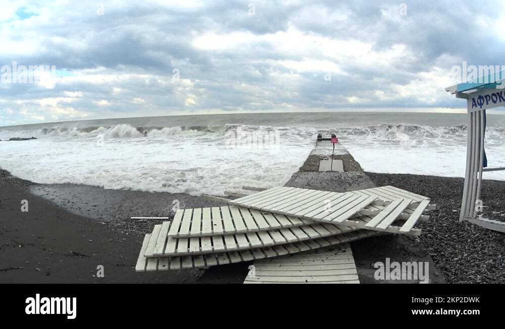 Storm on the beach. Scattered fence, huge waves washing everything into ...