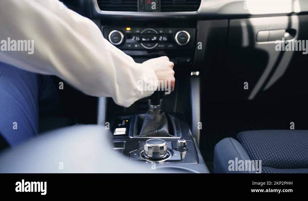 Female driving, changing gear. Hand of driver girl in white shirt ...