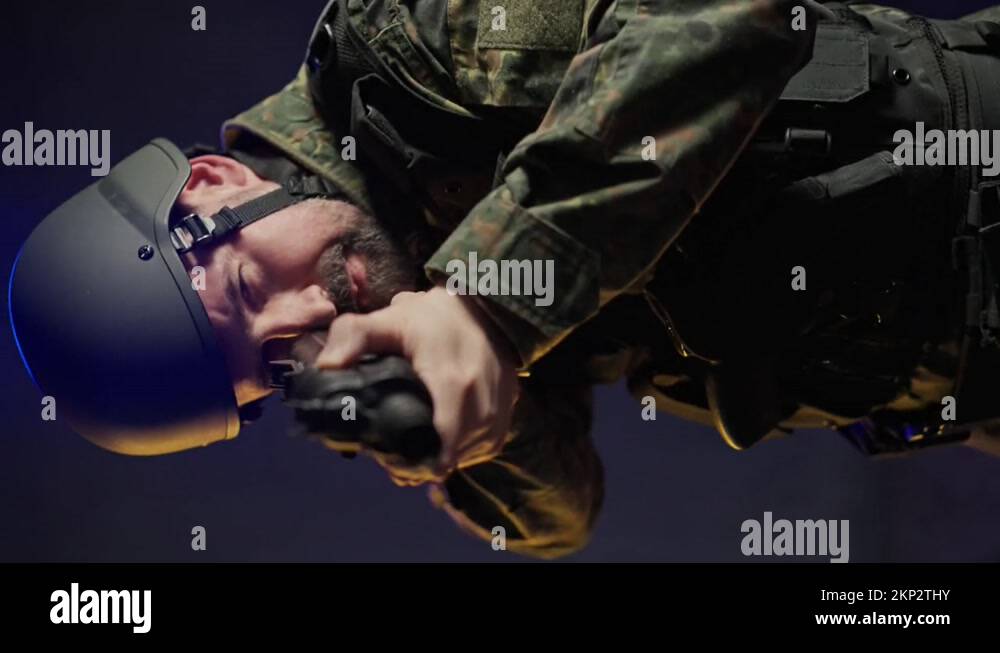Soldier in military uniform and helmet aiming with weapon to camera on ...