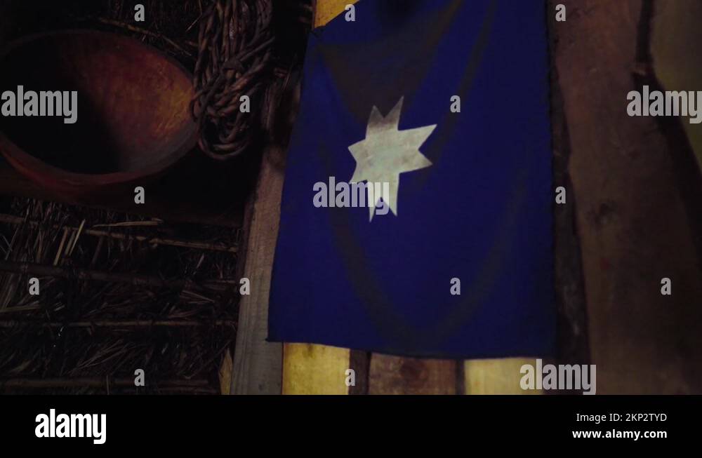 Handheld of a blue Guñelve Mapuche flag hanging from the interior wall ...