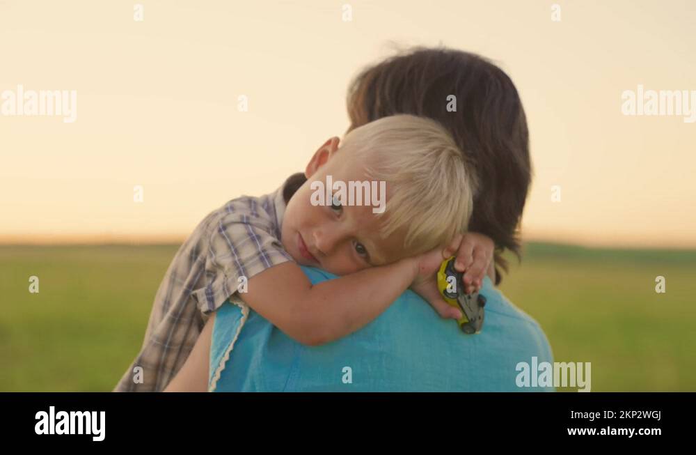 Happy cute affectionate mother hugs her beloved kid, son on walk in ...