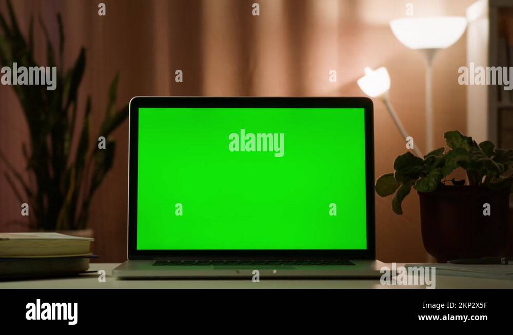 Modern laptop with mock up chroma key green screen on desk of living ...