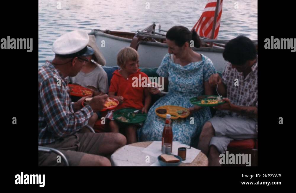 1960s: A family of four and a boat captain eat off plates in back of ...