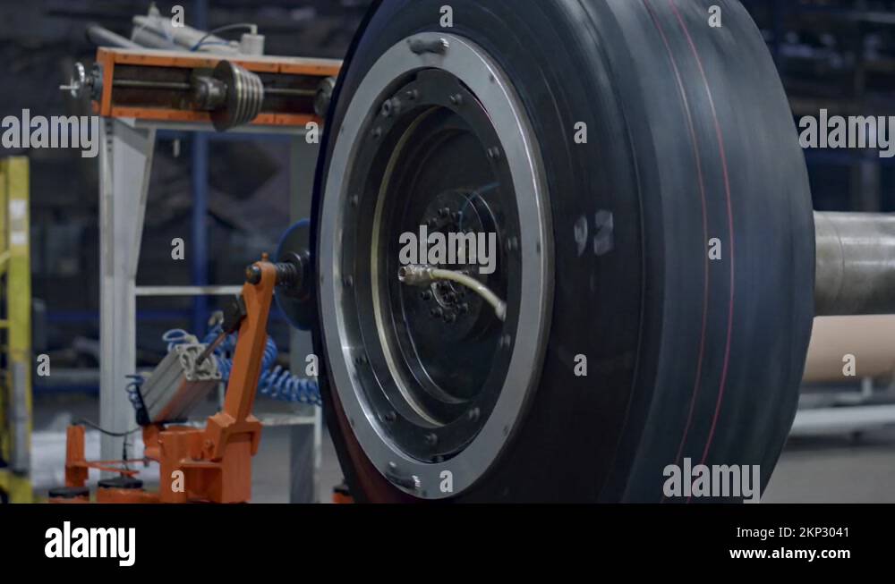 Tyre production machine rotating with new car rubber tire at industrial ...
