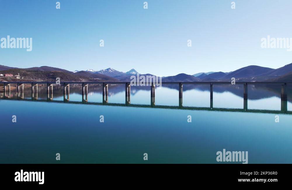 Long beam bridge over a huge, clear blue lake in León, Spain. Steel ...